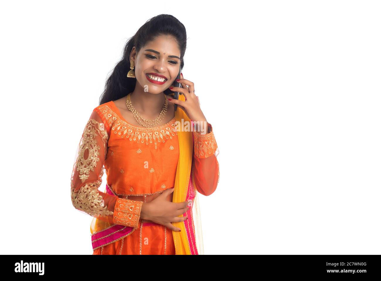 Young Indian traditional girl using a mobile phone or smartphone ...