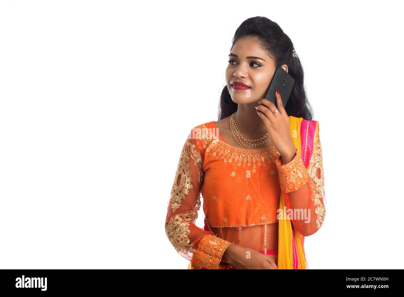 Young Indian traditional girl using a mobile phone or smartphone ...