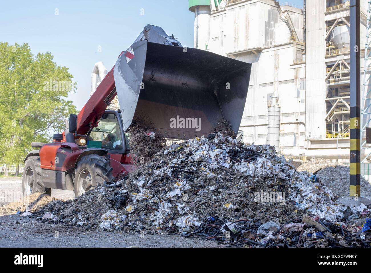 Front loader dumping waste materials at a waste treatment plant Stock ...
