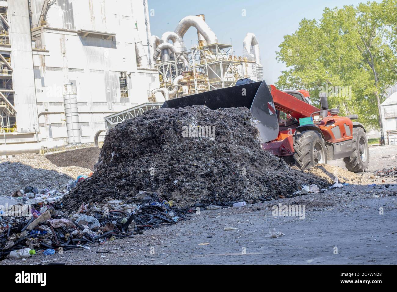 Front loader transporting industrial and communal waste materials in ...