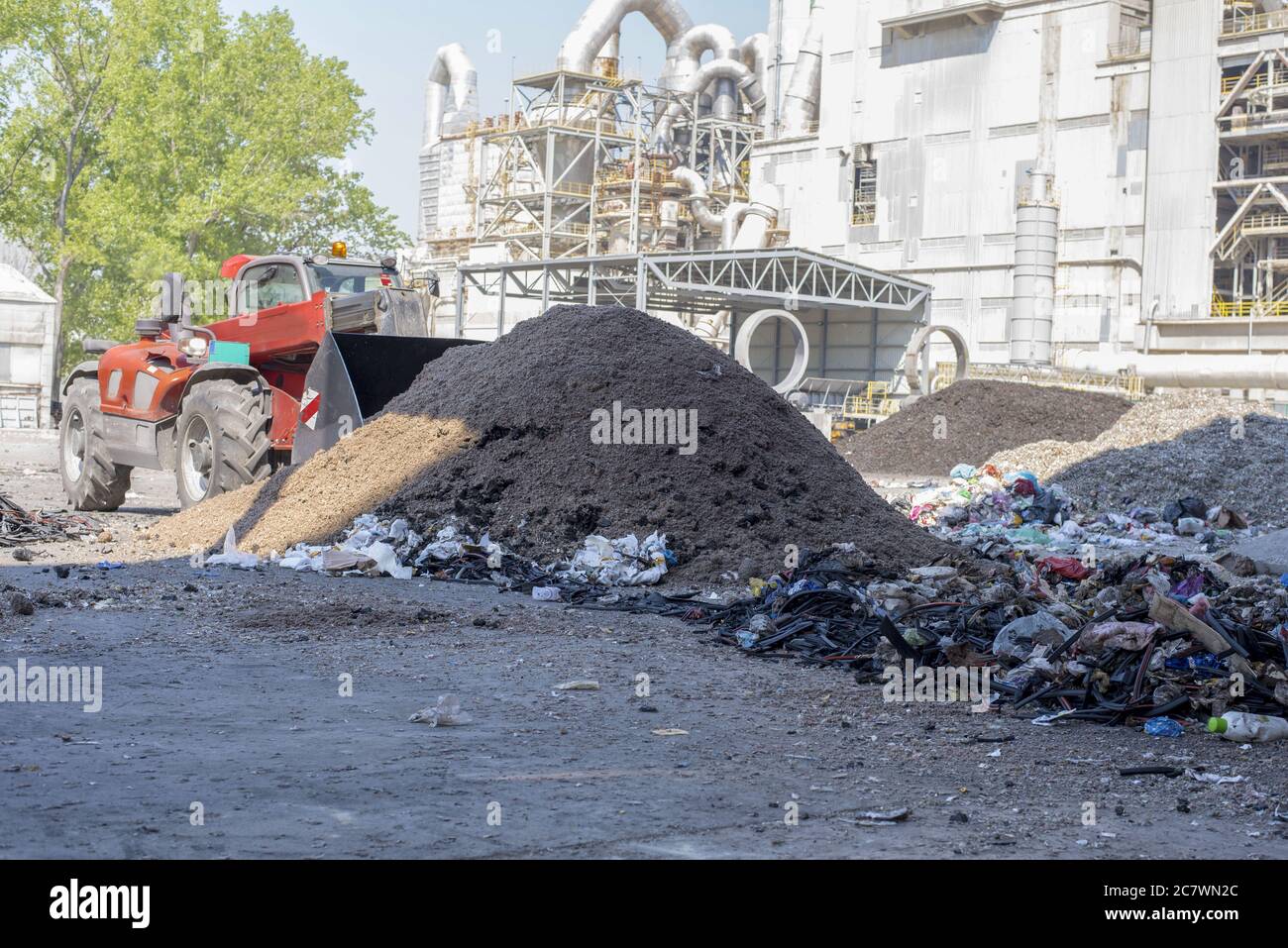 Front loader transporting industrial and communal waste materials in ...