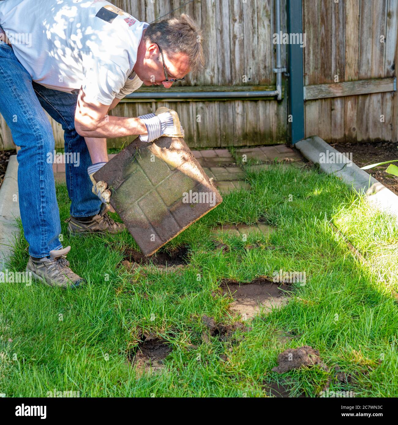 Square stepping stone lifted from the ground by a worker Stock Photo ...