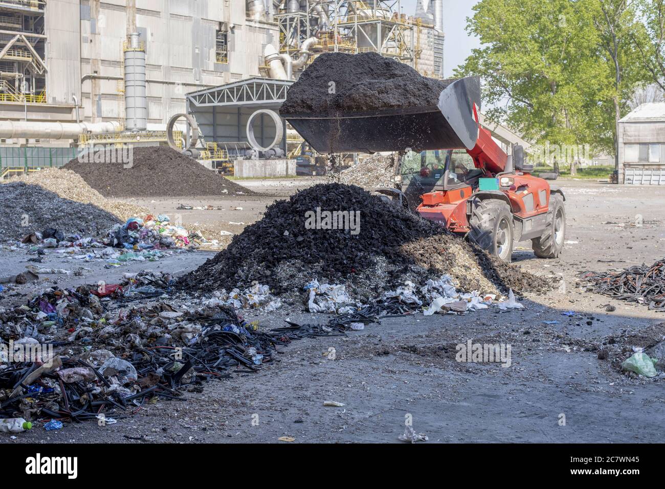 Front loader transporting industrial and communal waste materials in ...