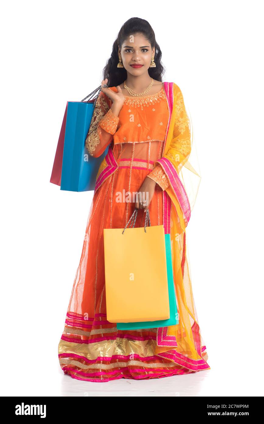 Beautiful Indian young girl holding shopping bags while wearing ...