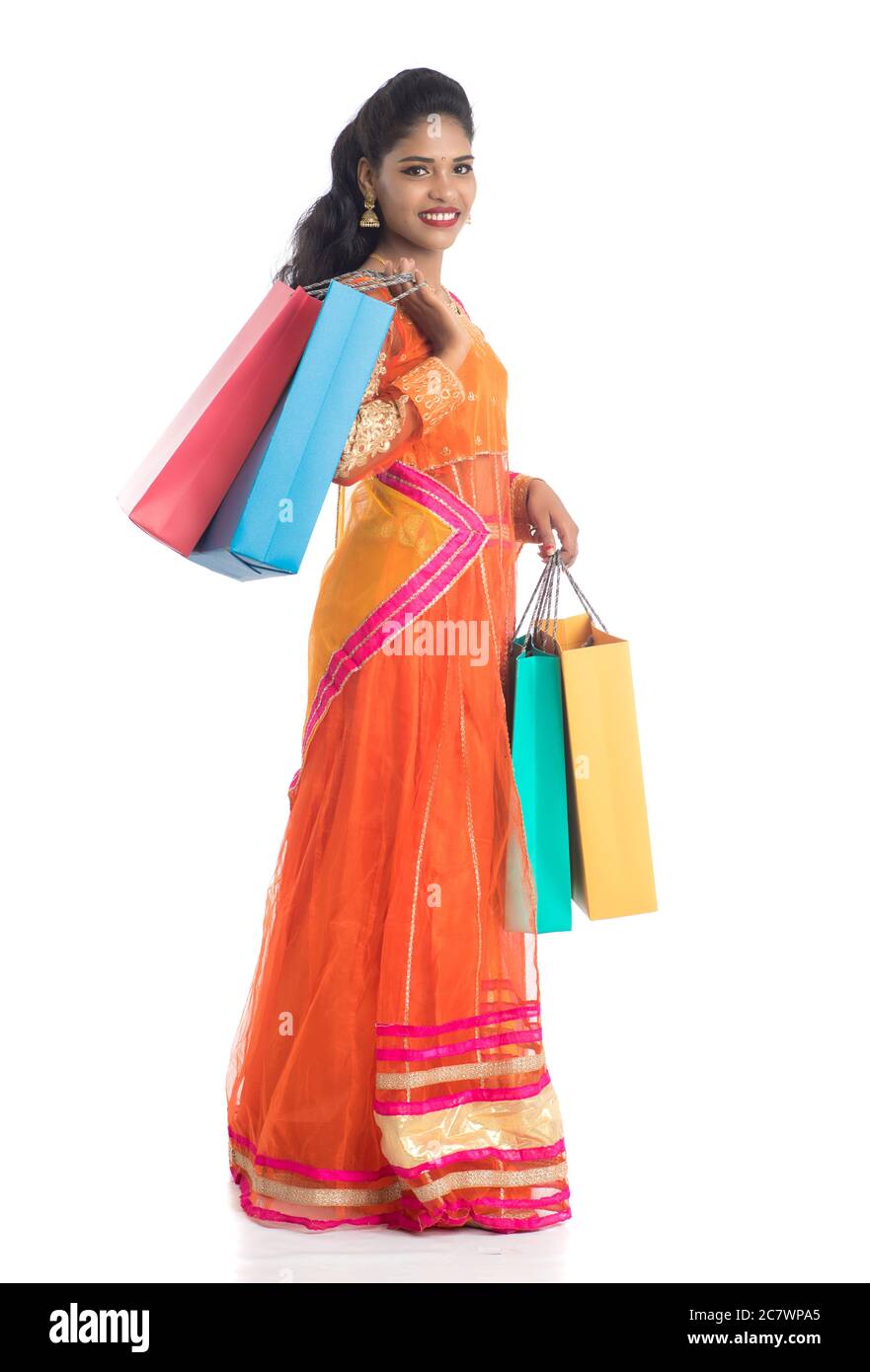 Beautiful Indian young girl holding shopping bags while wearing ...