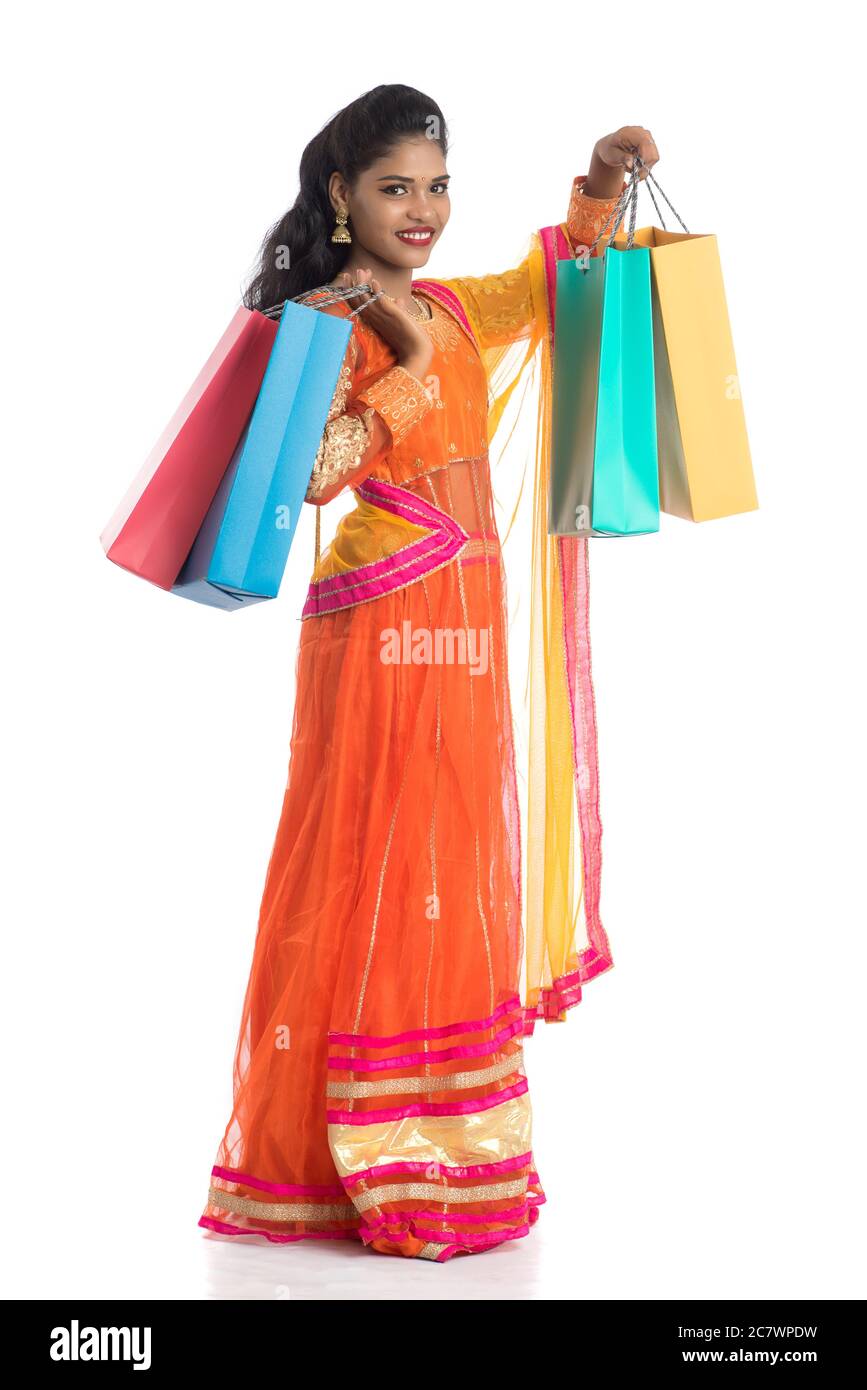 Beautiful Indian young girl holding shopping bags while wearing ...