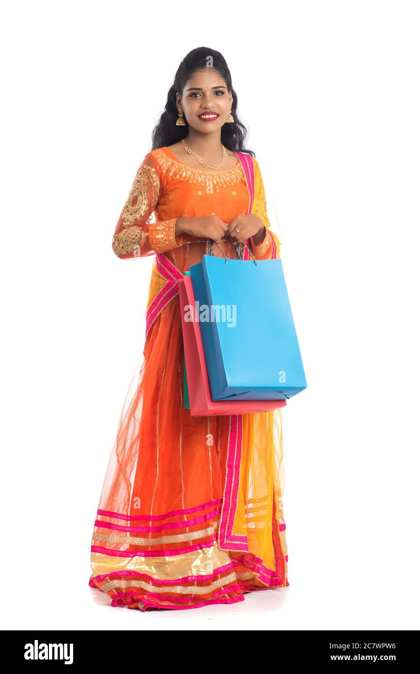Beautiful Indian young girl holding shopping bags while wearing ...