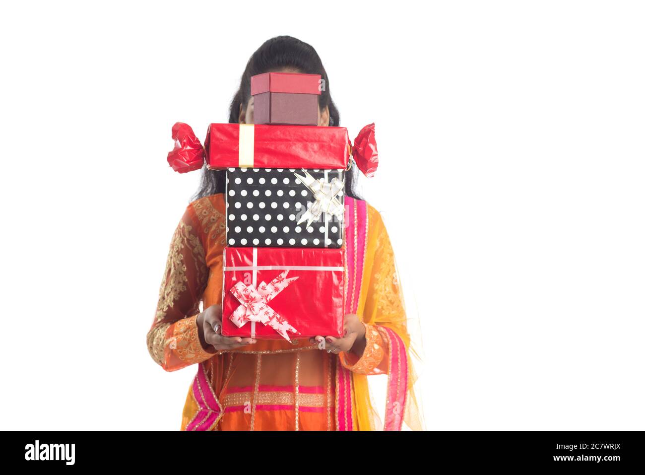 Portrait of young happy smiling Indian Girl holding gift boxes on a ...