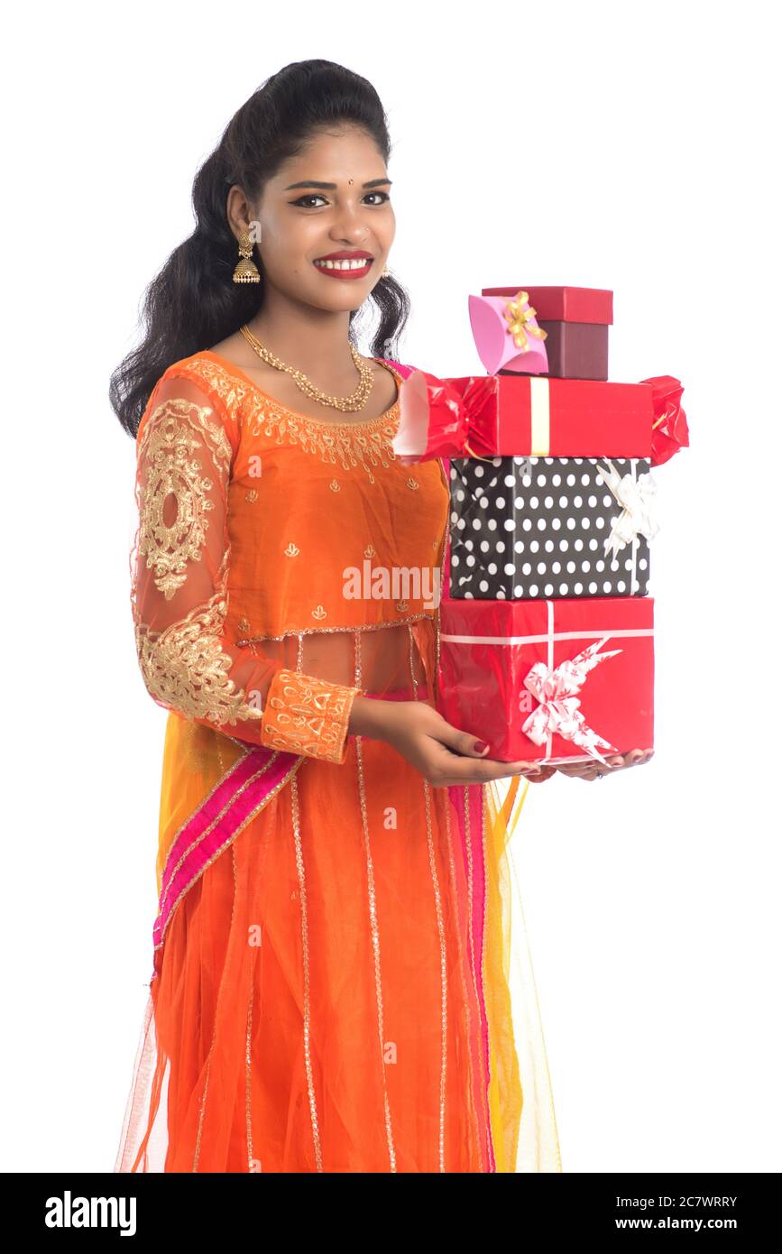 Portrait of young happy smiling Indian Girl holding gift boxes on a ...