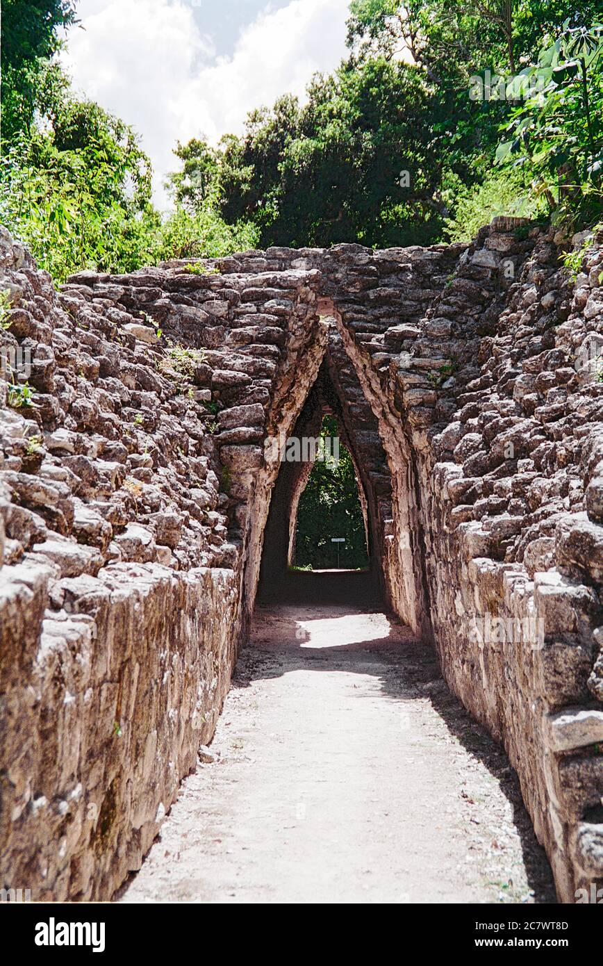 Following a path through the ruins is a typical Mayan gate or doorway ...