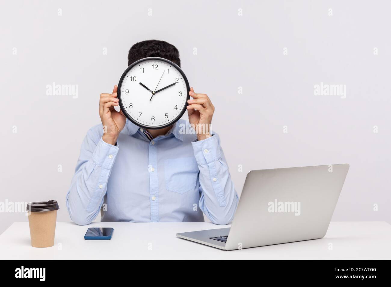 Time to work! Male employee sitting in office workplace and covering ...