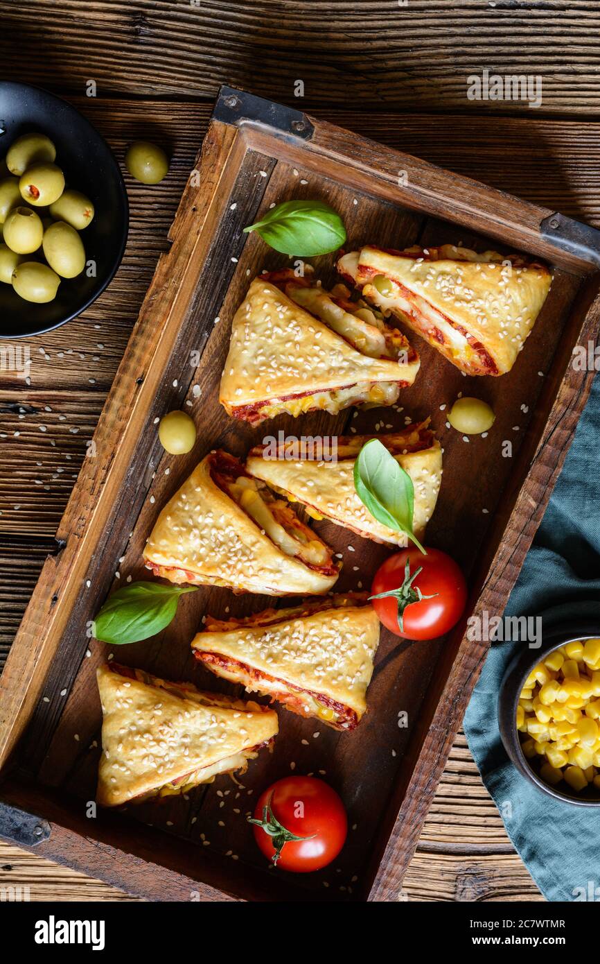 Delicious puff pastry pizza triangle rolls stuffed with tomato sauce ...