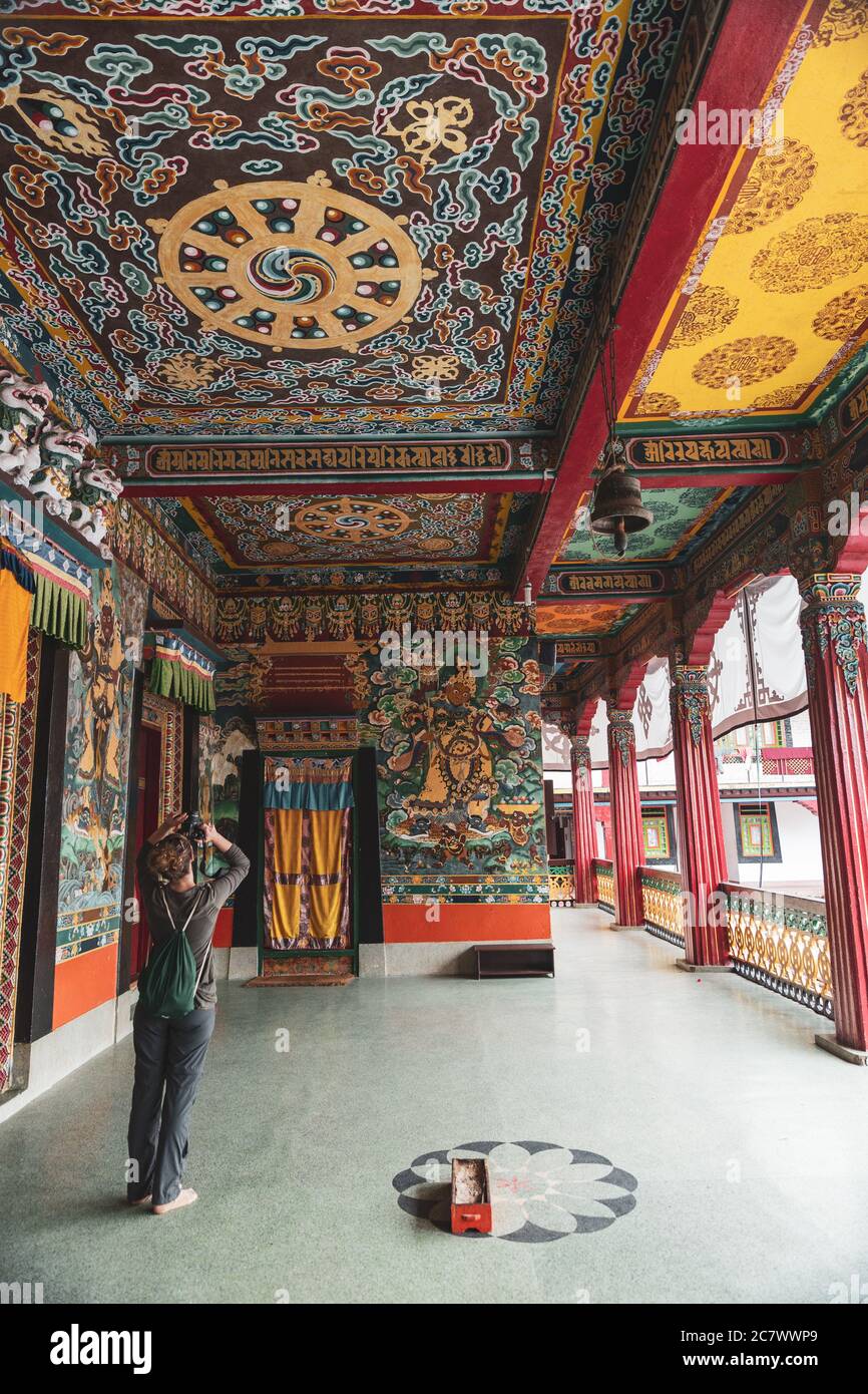 A tourist photographer takings photographs of Arts on walls of Rumtek ...