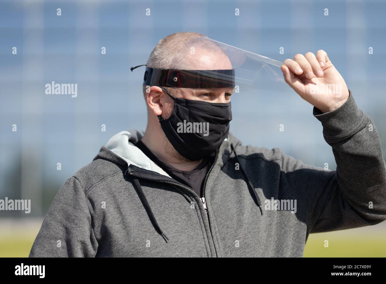 Adult bolt man posing in a protective transparent visor and a black ...