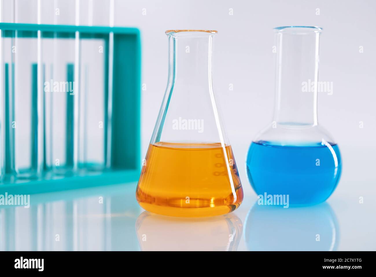 Closeup shot of an Erlenmeyer flask with orange liquid and a round ...