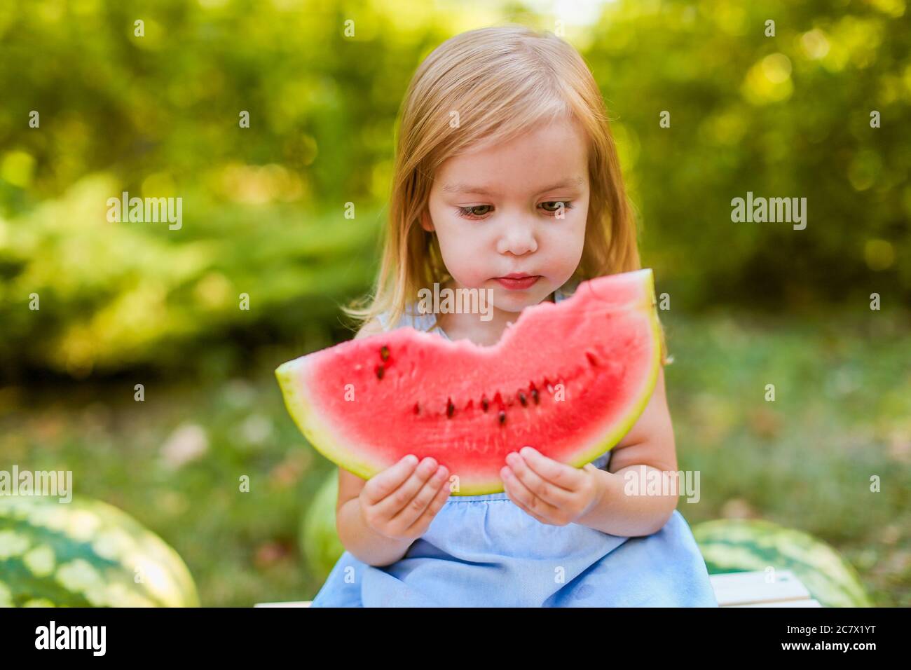 Child eating watermelon in the garden. Kids eat fruit outdoors. Healthy ...