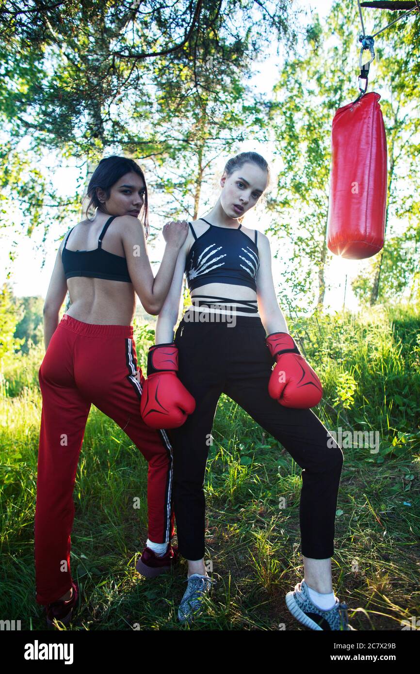 two diverse nations girls fighting boxing outside in green park, sport ...
