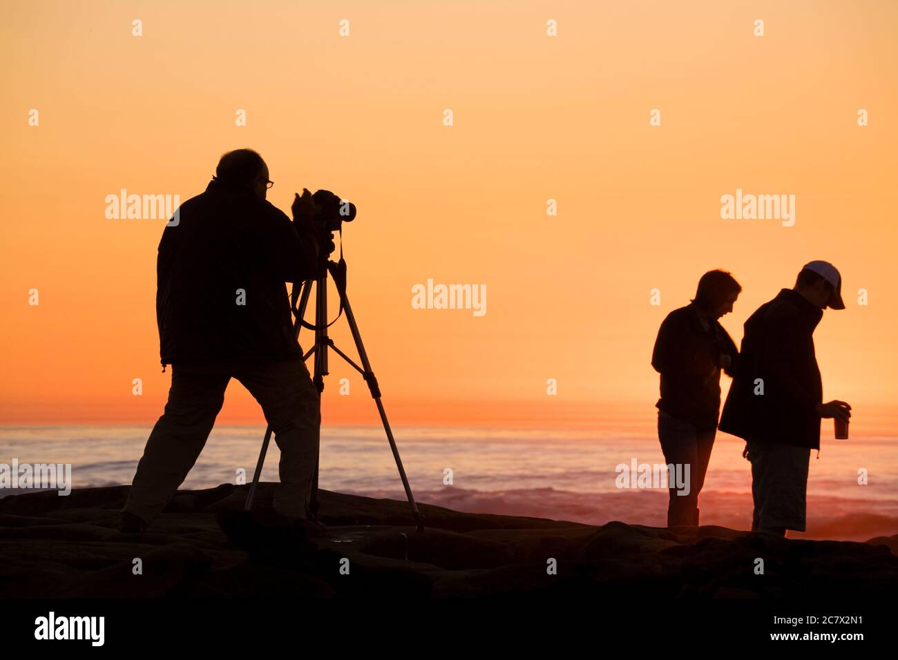 Man photographing the sunset, La Jolla, San Diego County, California ...