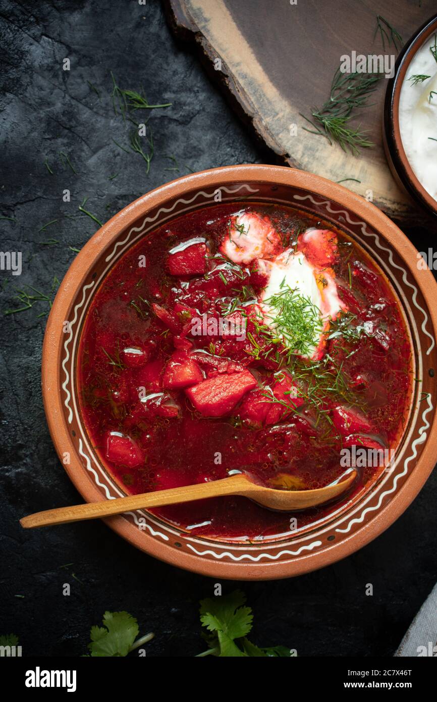 Vegetarian borstch served in traditional clay bowl on dark background ...