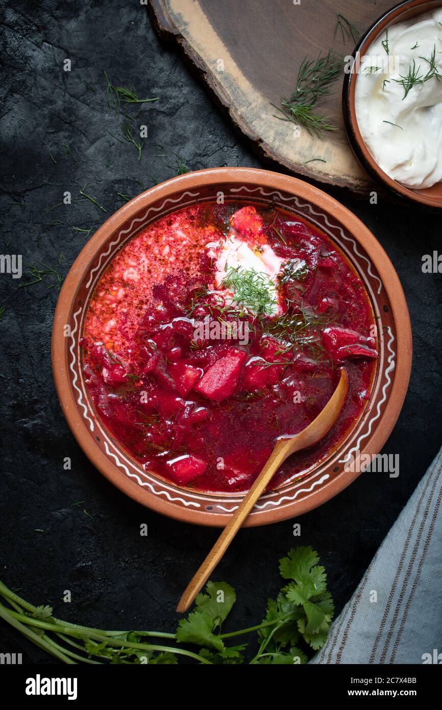 Vegetarian borstch served in traditional clay bowl on dark background ...