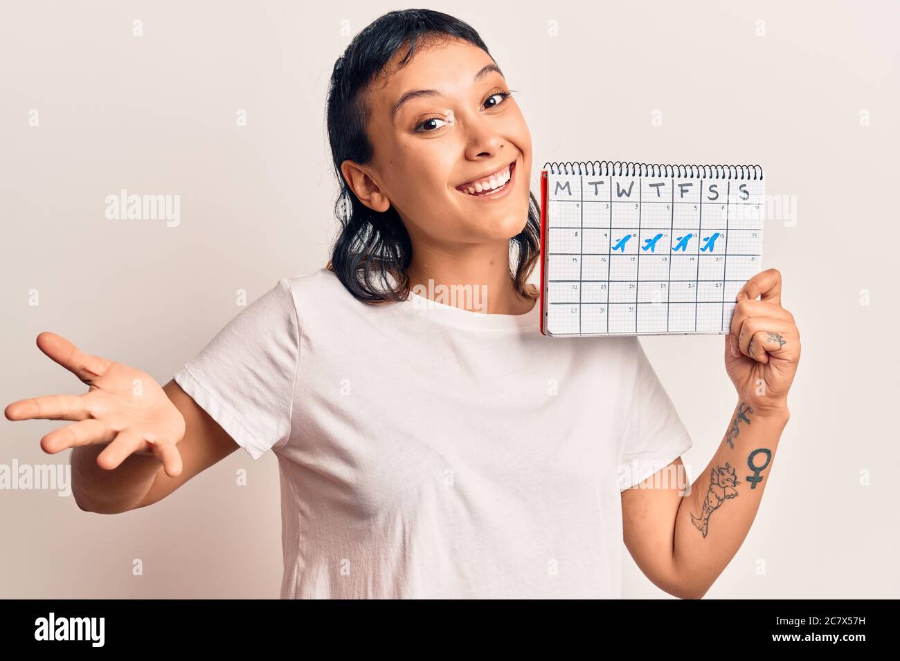 Young woman holding travel calendar celebrating achievement with happy ...