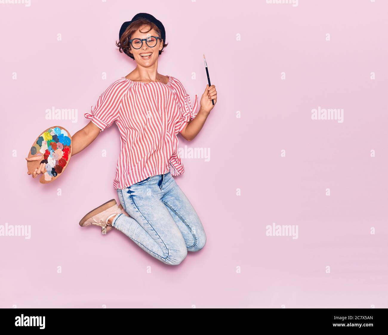 Young beautiful artist woman wearing glasses and beret smiling happy ...
