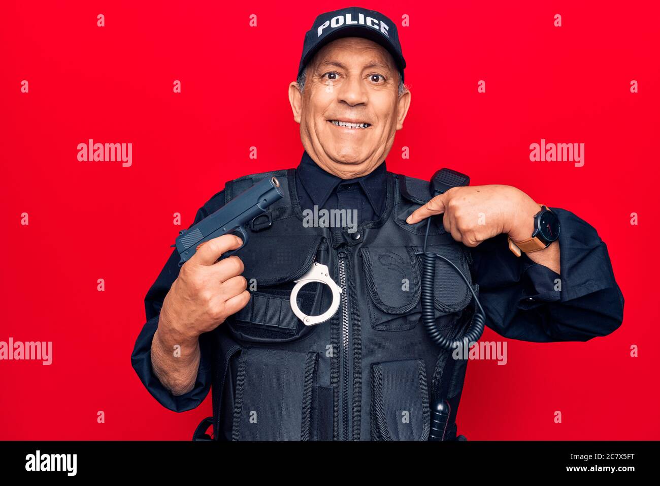 Senior man with grey hair wearing police uniform holding gun pointing ...