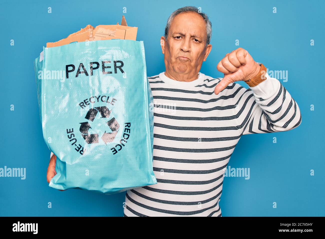 Senior grey-haired man recycling holding bag with cardboard to recycle ...