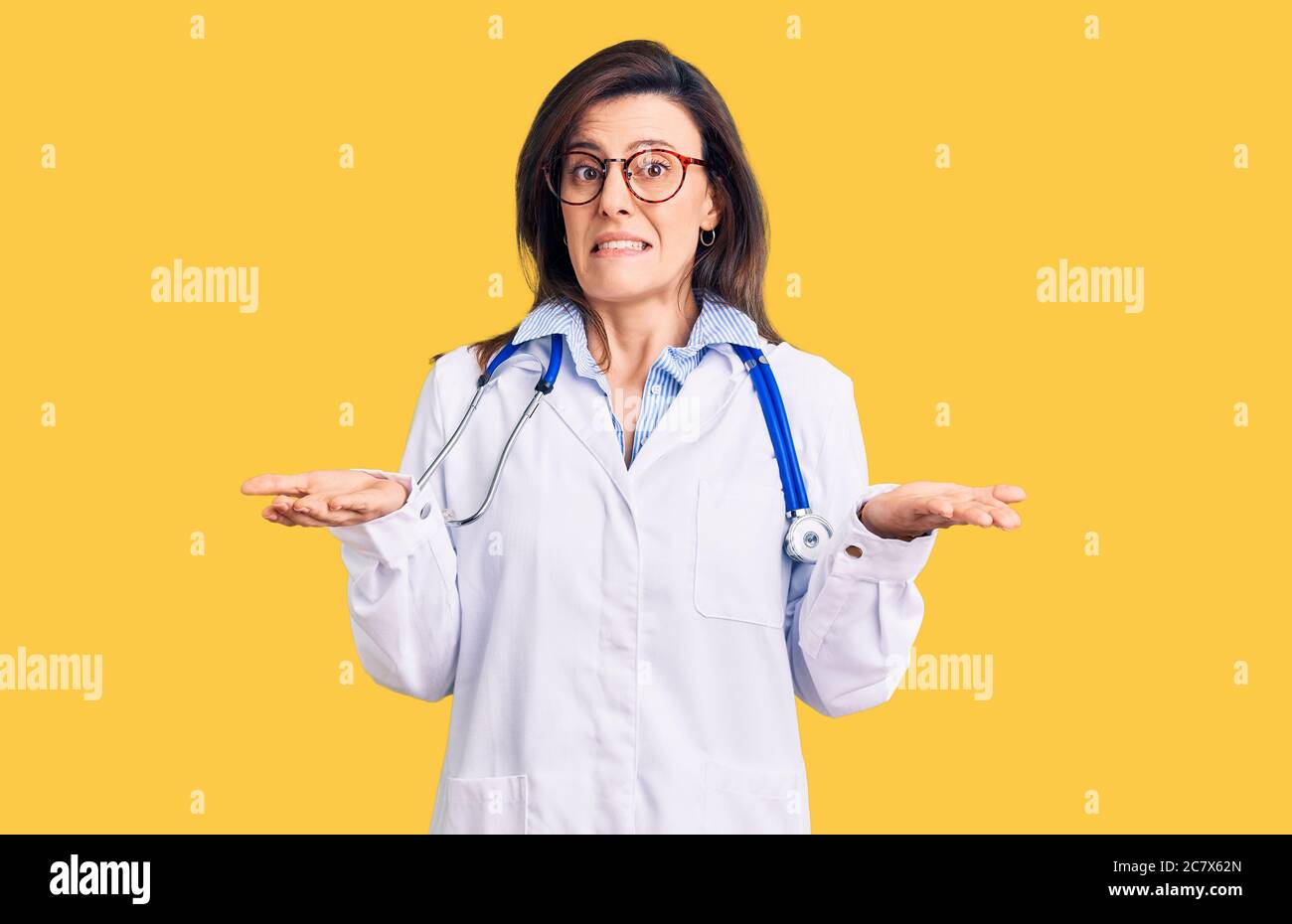 Young beautiful woman wearing doctor stethoscope and glasses clueless ...