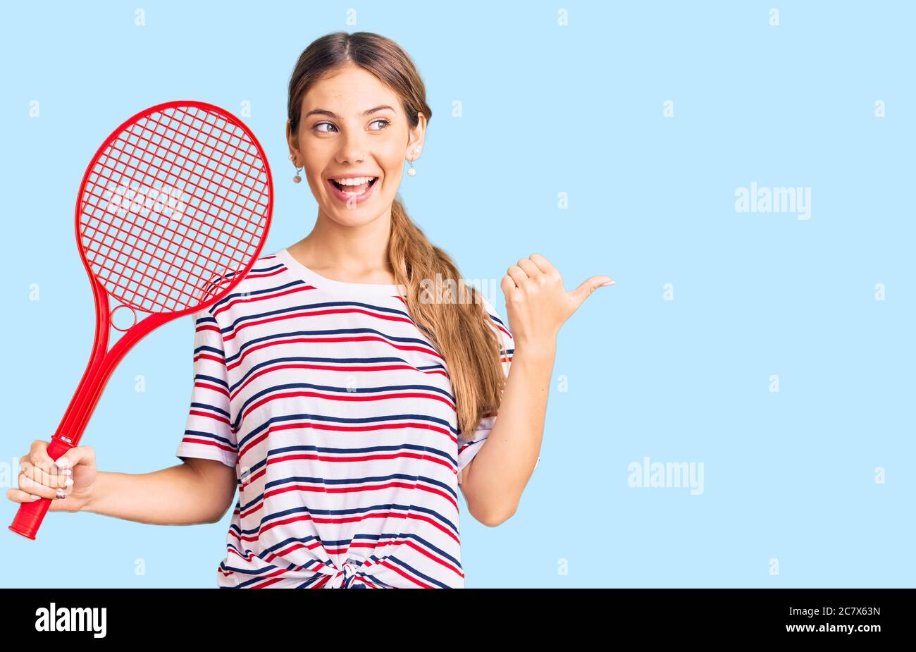 Beautiful caucasian woman with blonde hair playing tennis holding ...