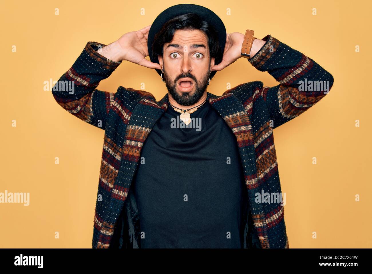 Young handsome hispanic bohemian man wearing hippie style and boho hat ...