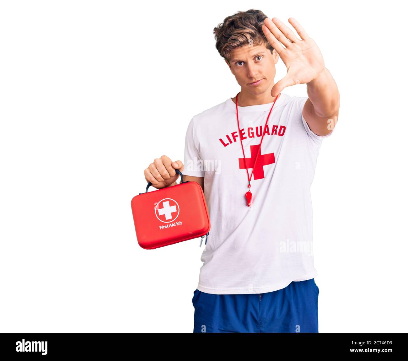 Young handsome man wearing lifeguard t shirt holding first aid kit with ...