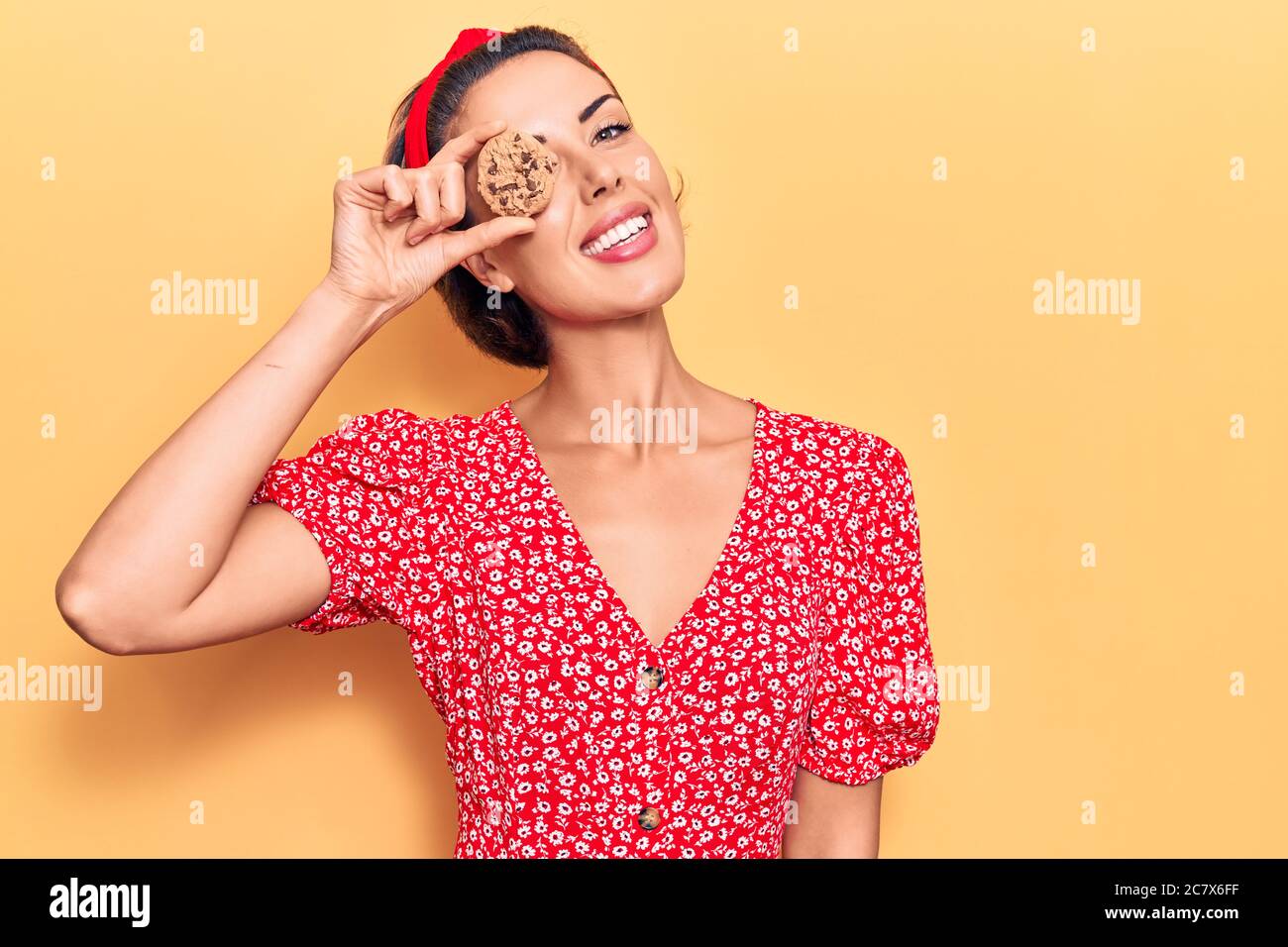 Young beautiful woman holding cookie looking positive and happy ...
