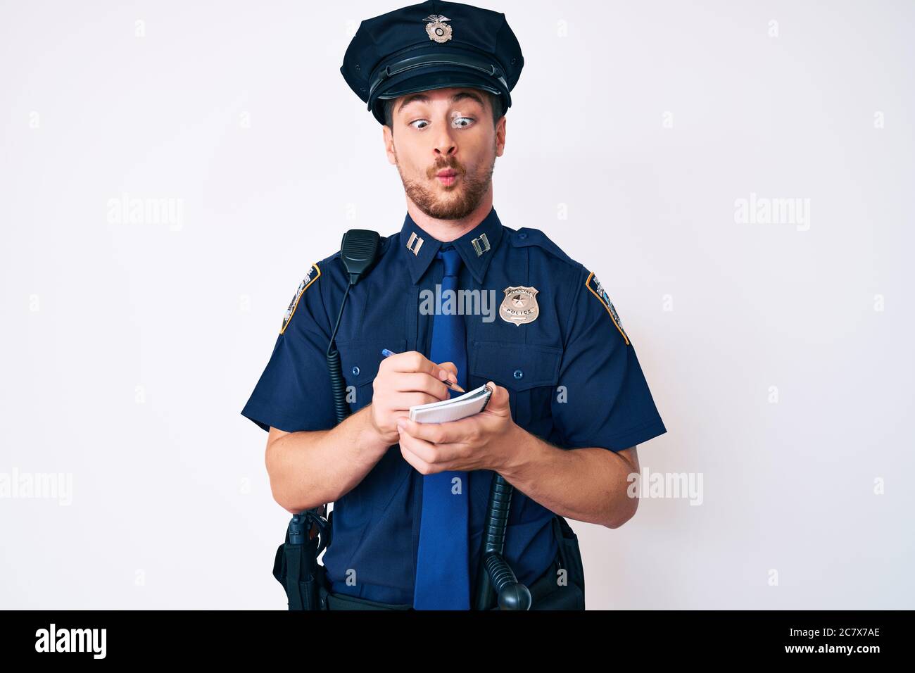 Young caucasian man wearing police uniform writing fine making fish ...