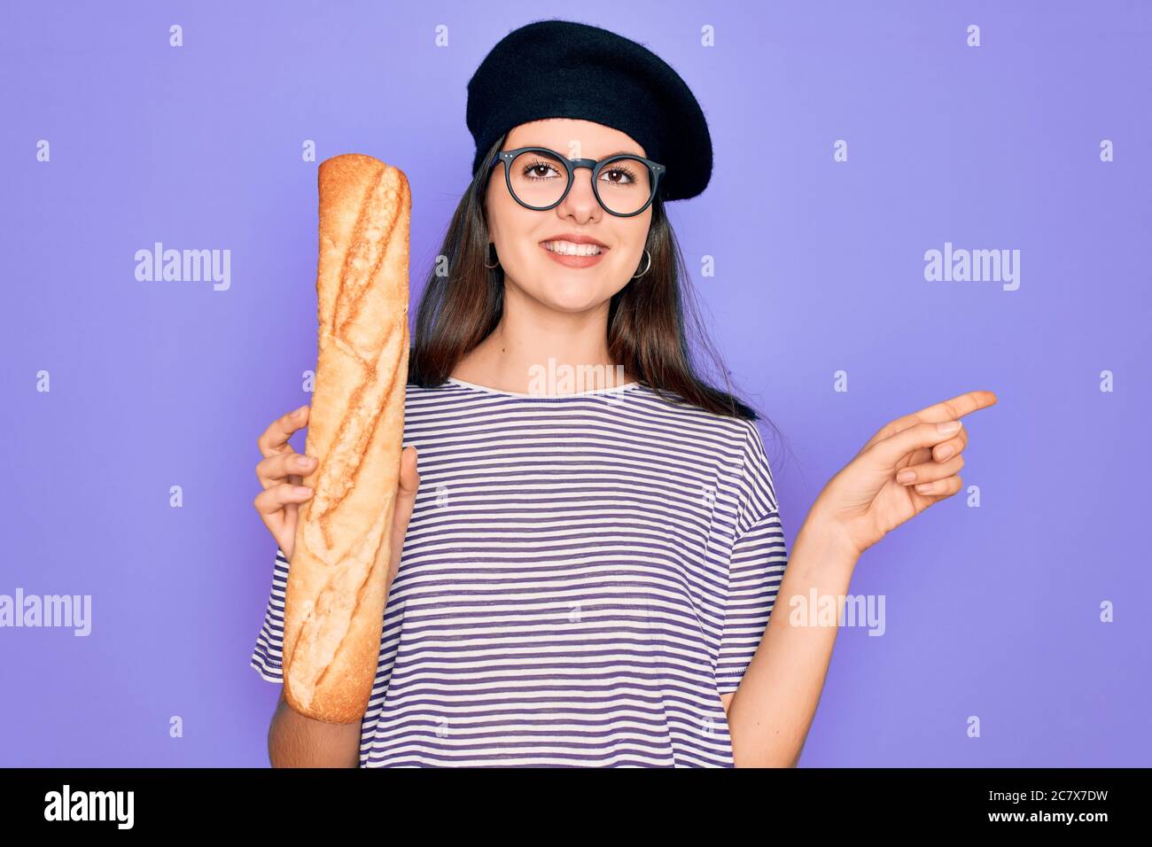 Young beautiful girl wearing fashion french beret holding fresh baked ...