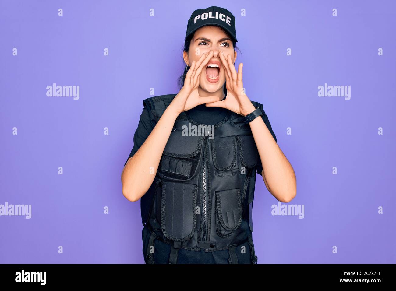 Young police woman wearing security bulletproof vest uniform over ...