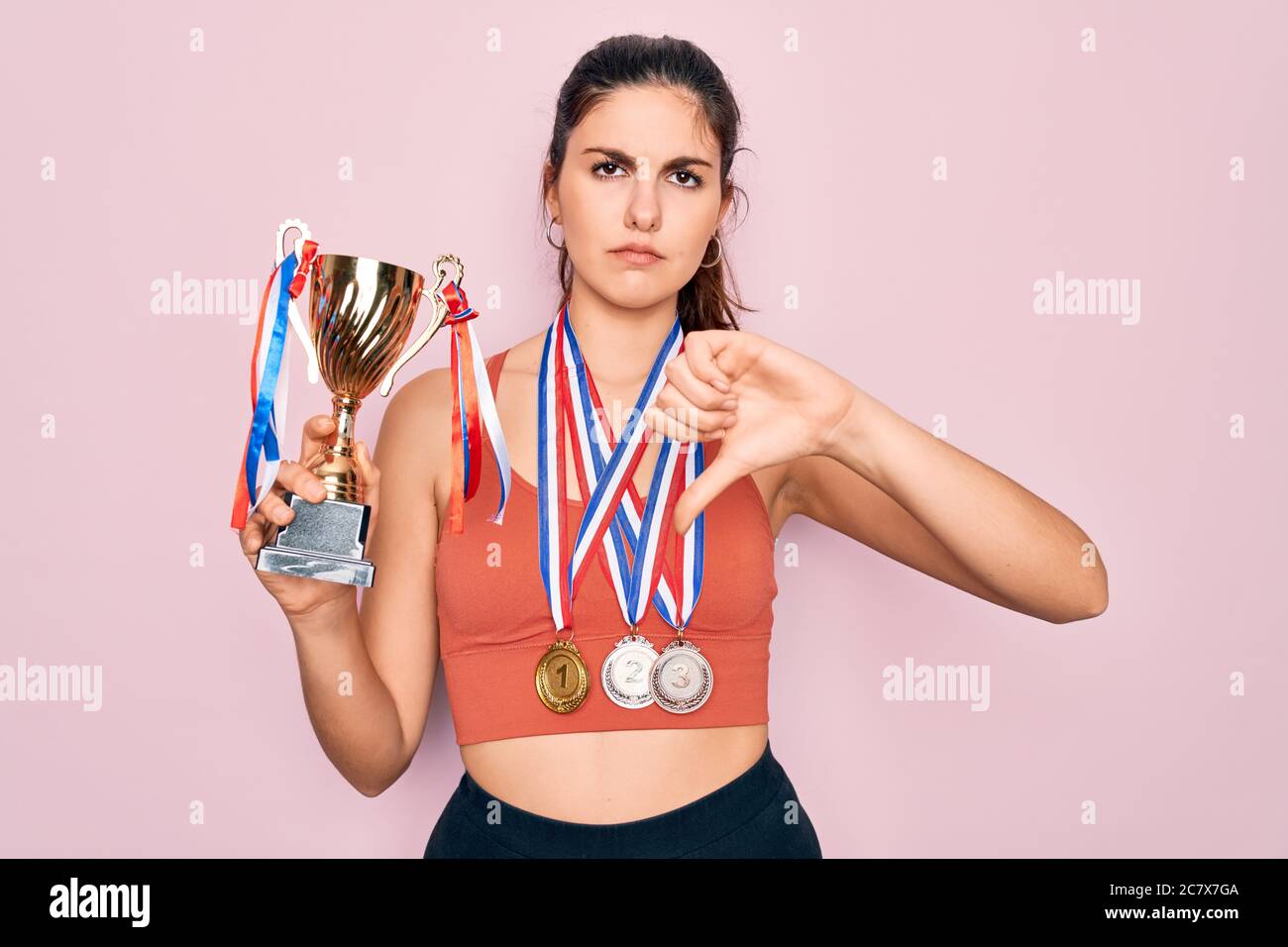 Young beautiful fitness winner athlete woman wearing sport medals and ...