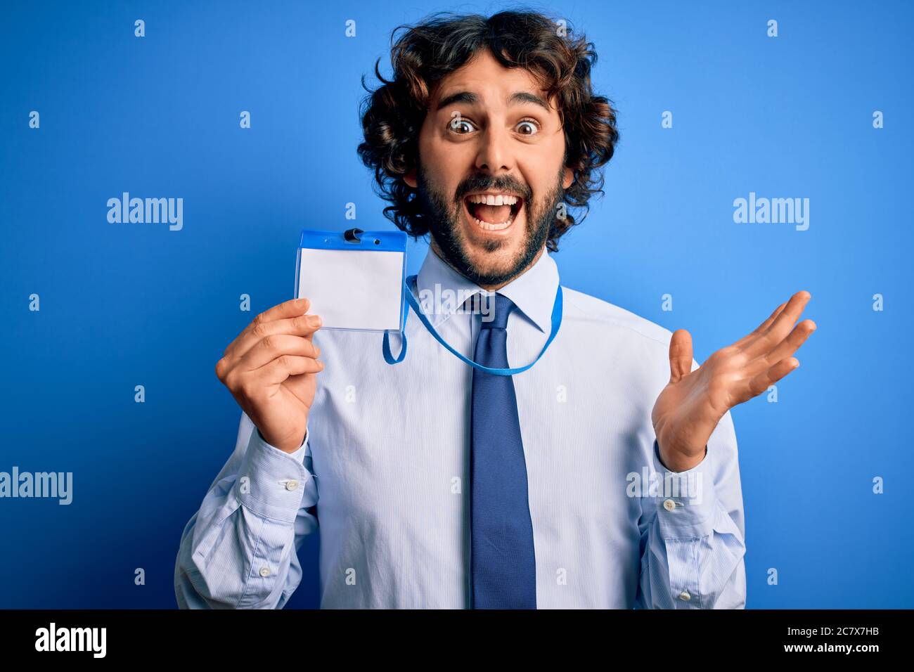 Young handsome business man with beard holding id card identification ...