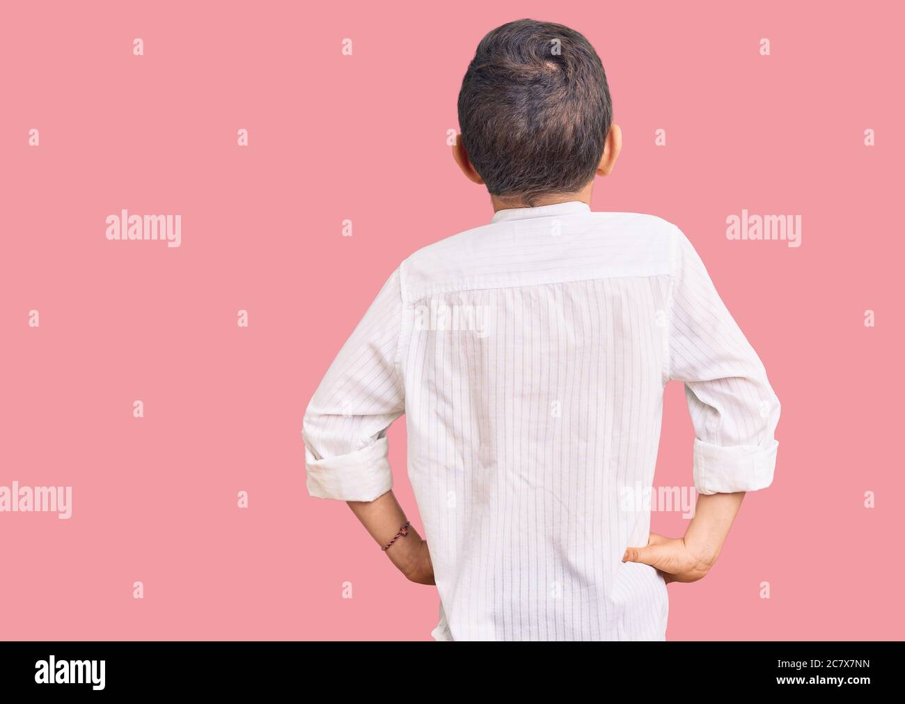 Cute blond kid wearing elegant shirt standing backwards looking away ...