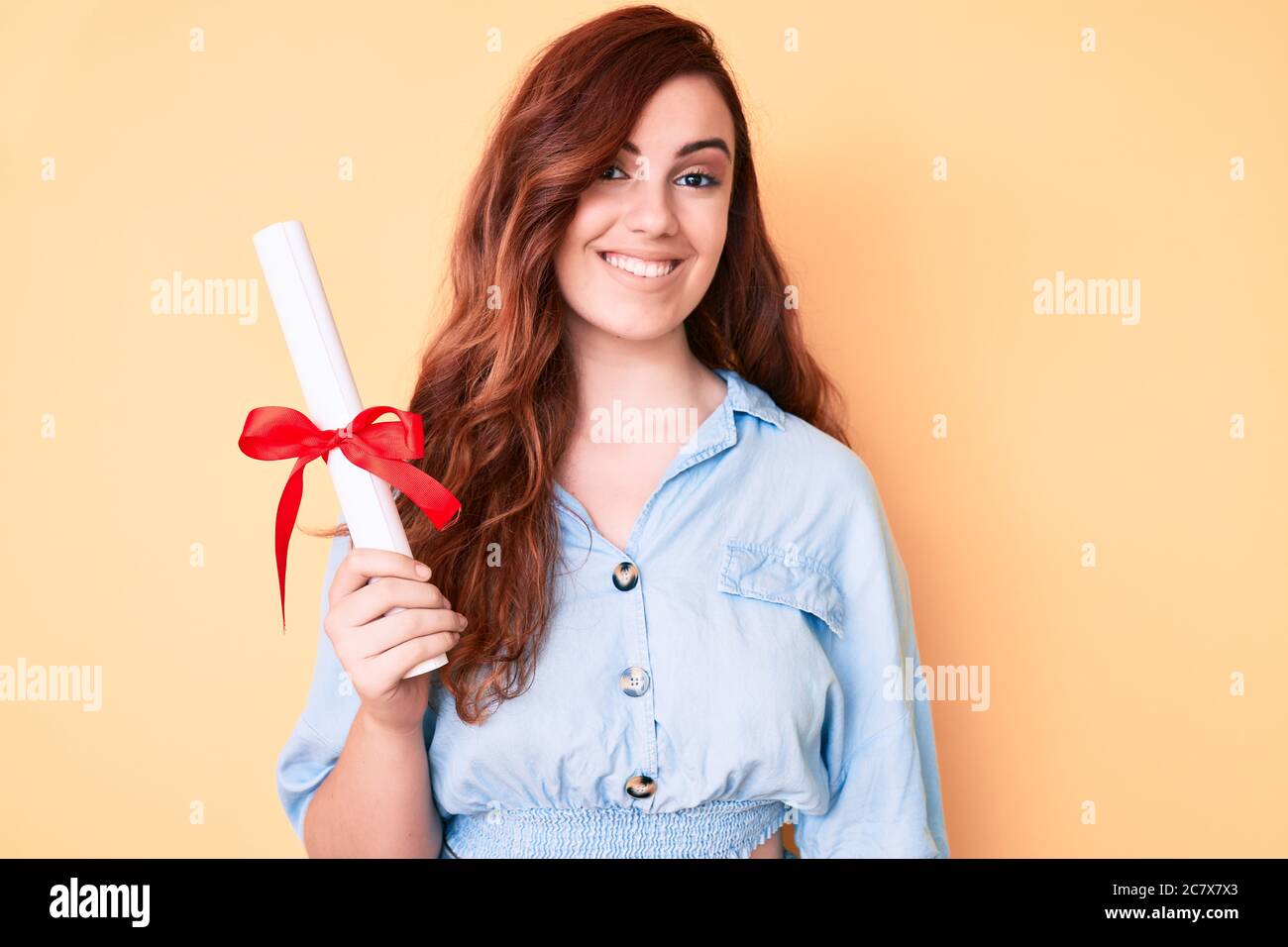 Young beautiful woman holding graduate degree diploma looking positive ...