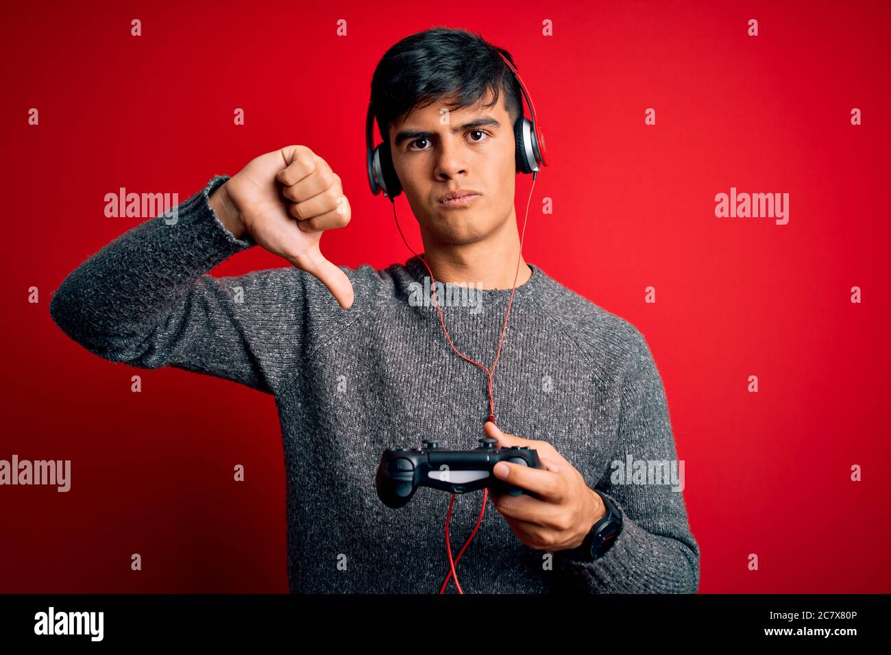 Young handsome gamer man playing video game using joystick and ...
