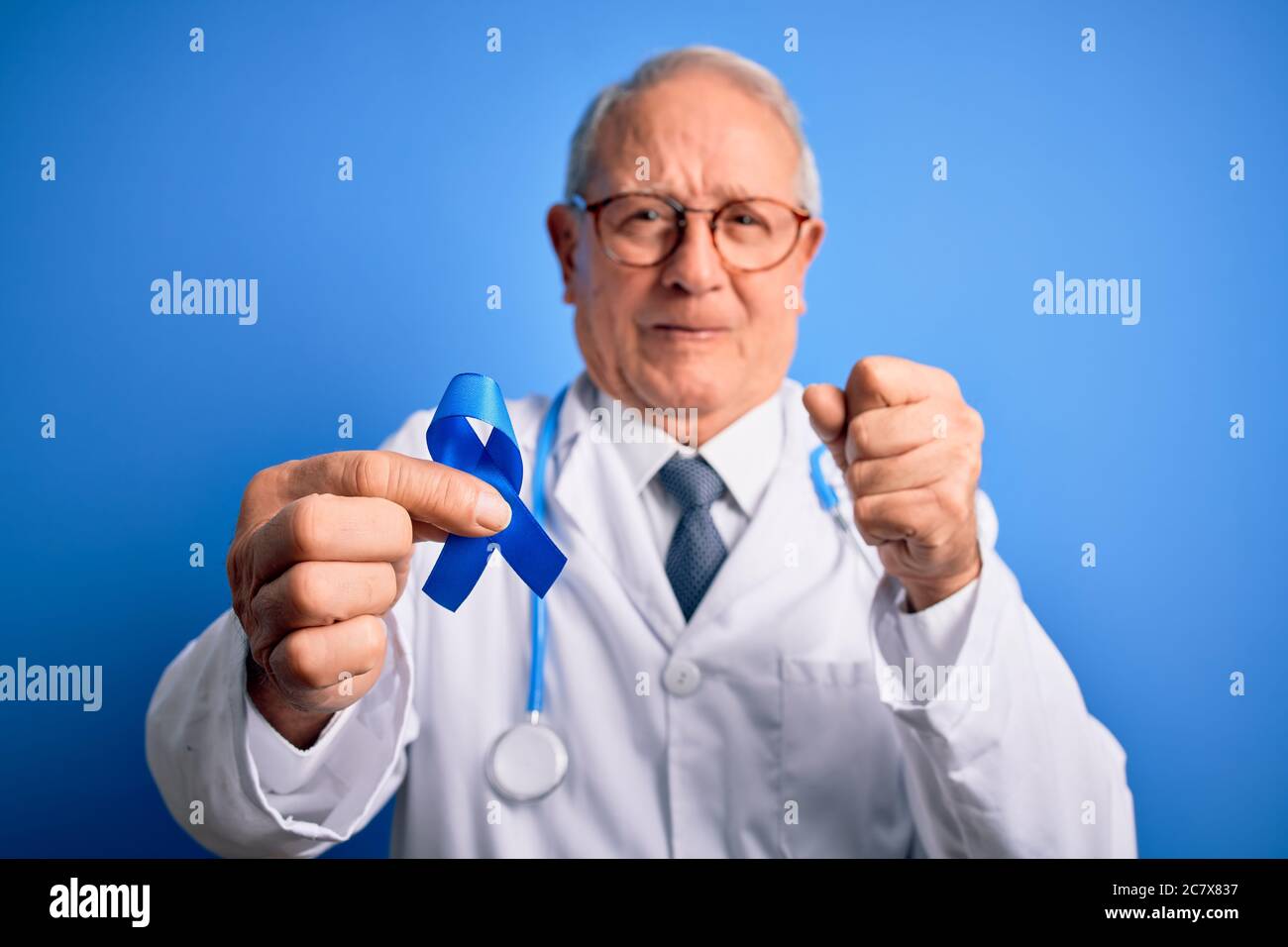 Grey haired senior doctor man holding colon cancer awareness blue ...