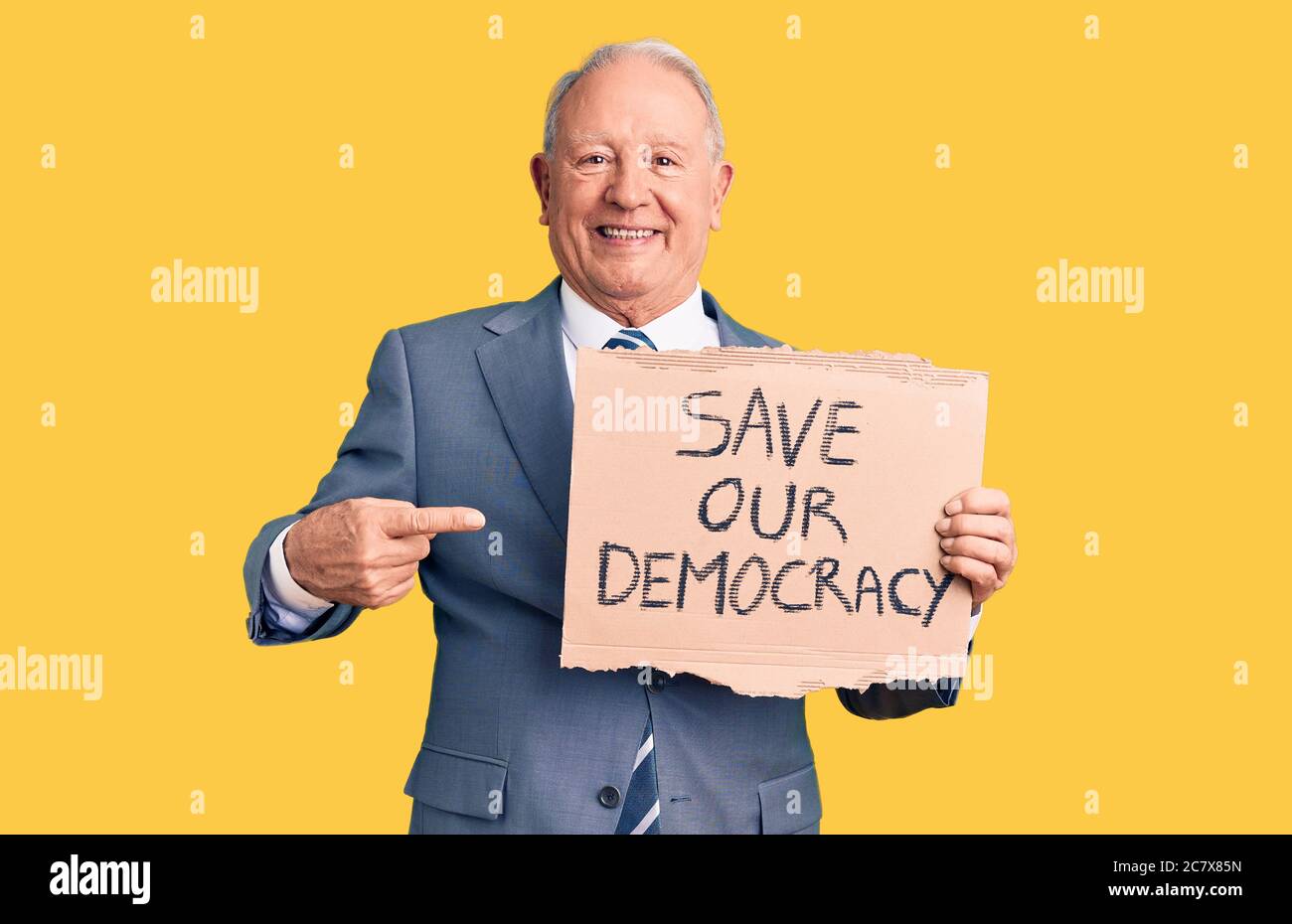 Senior handsome grey-haired man holding save our democracy cardboard ...