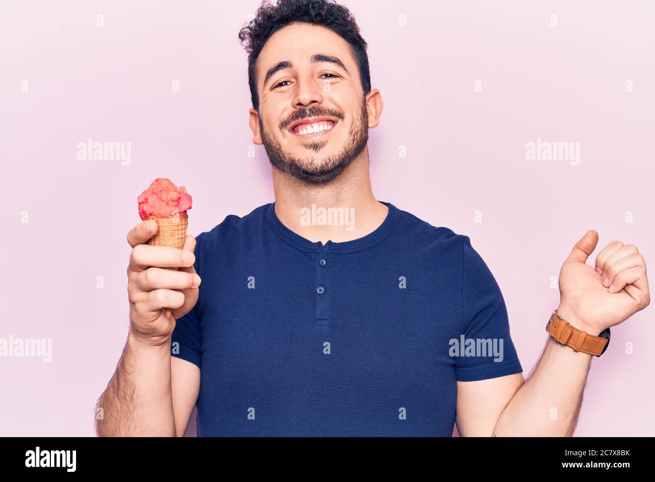 Young hispanic man holding ice cream screaming proud, celebrating ...