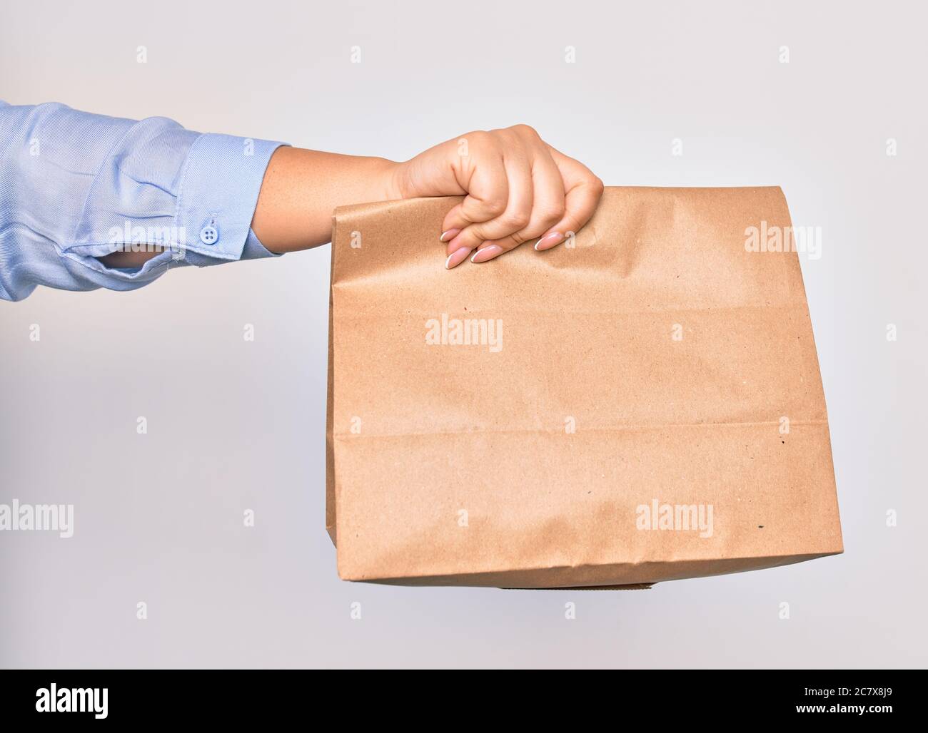Hand of caucasian young woman holding deliver paper bag of takeaway ...