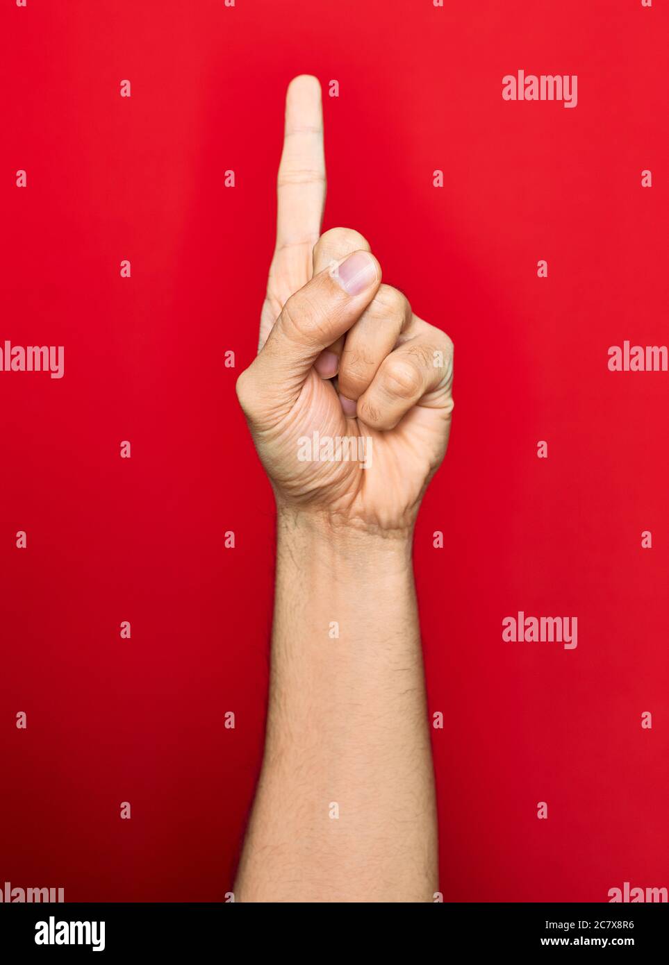 Beautiful hand of man raised up showing one finger over isolated red ...