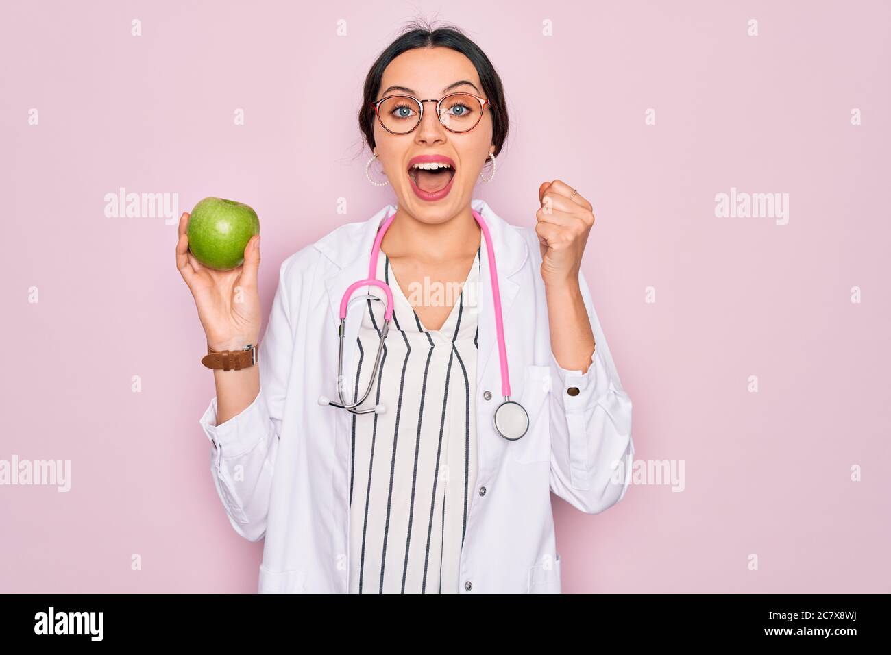 Young beautiful doctor woman with blue eyes wearing stethoscope holding ...