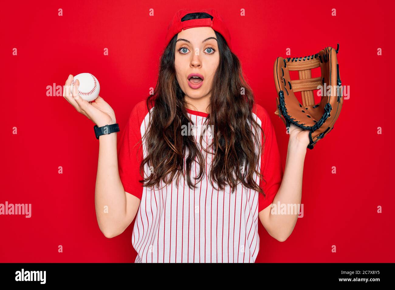 Young beautiful sportswoman with blue eyes playing baseball using glove ...