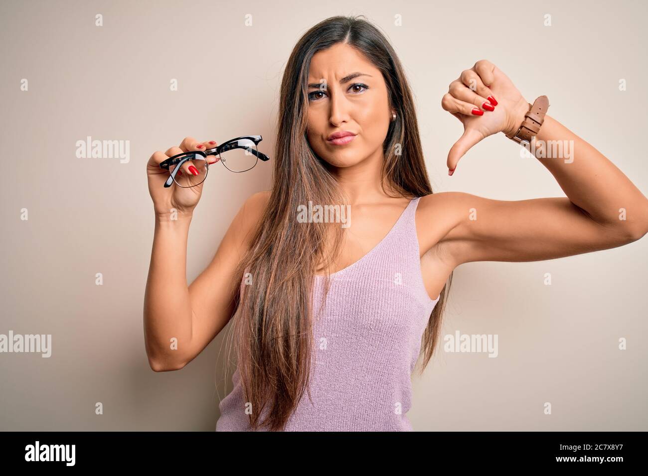 Young beautiful brunette optical woman holding vision glasses over ...