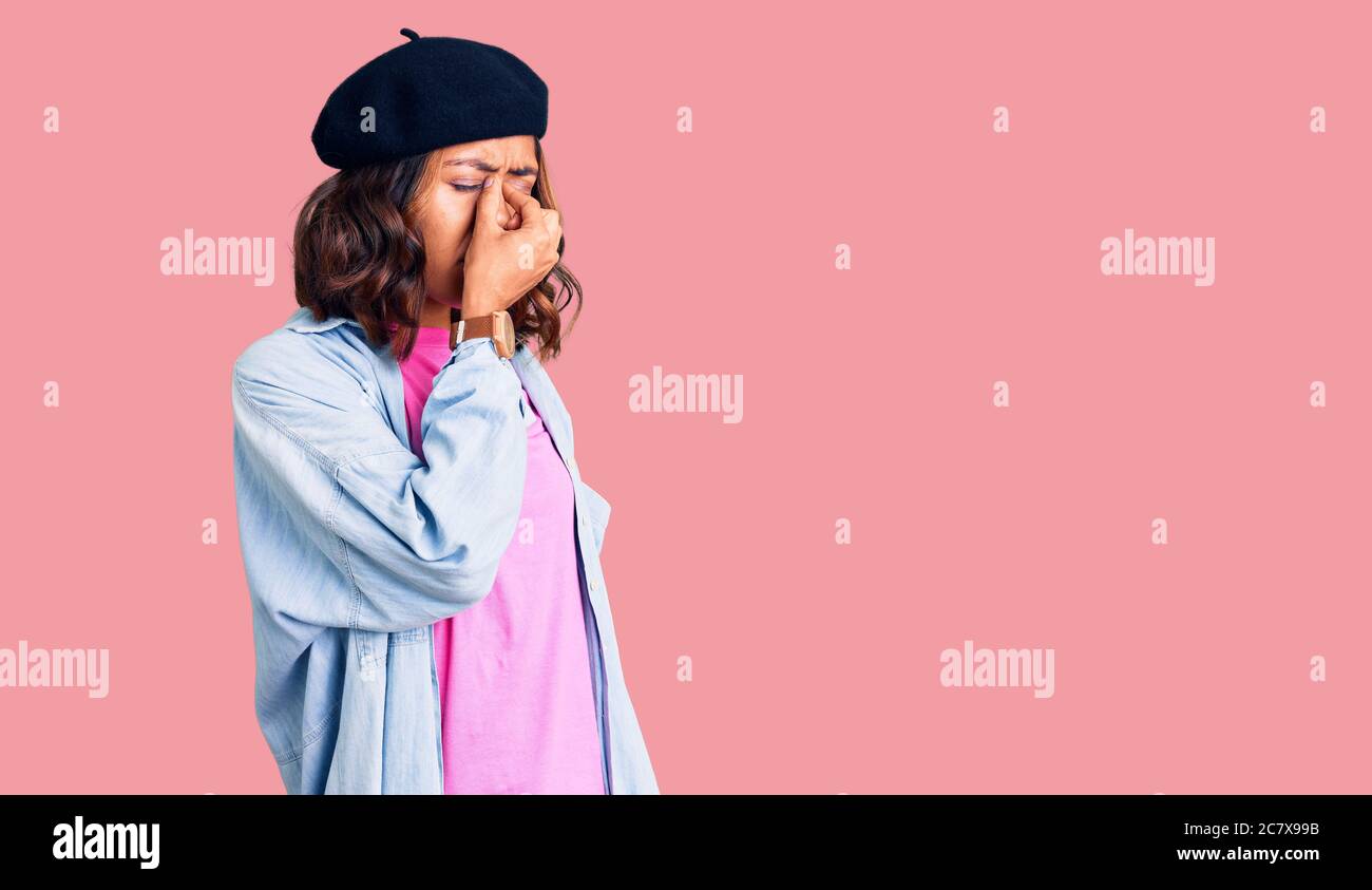 Young beautiful mixed race woman wearing french look with beret tired ...